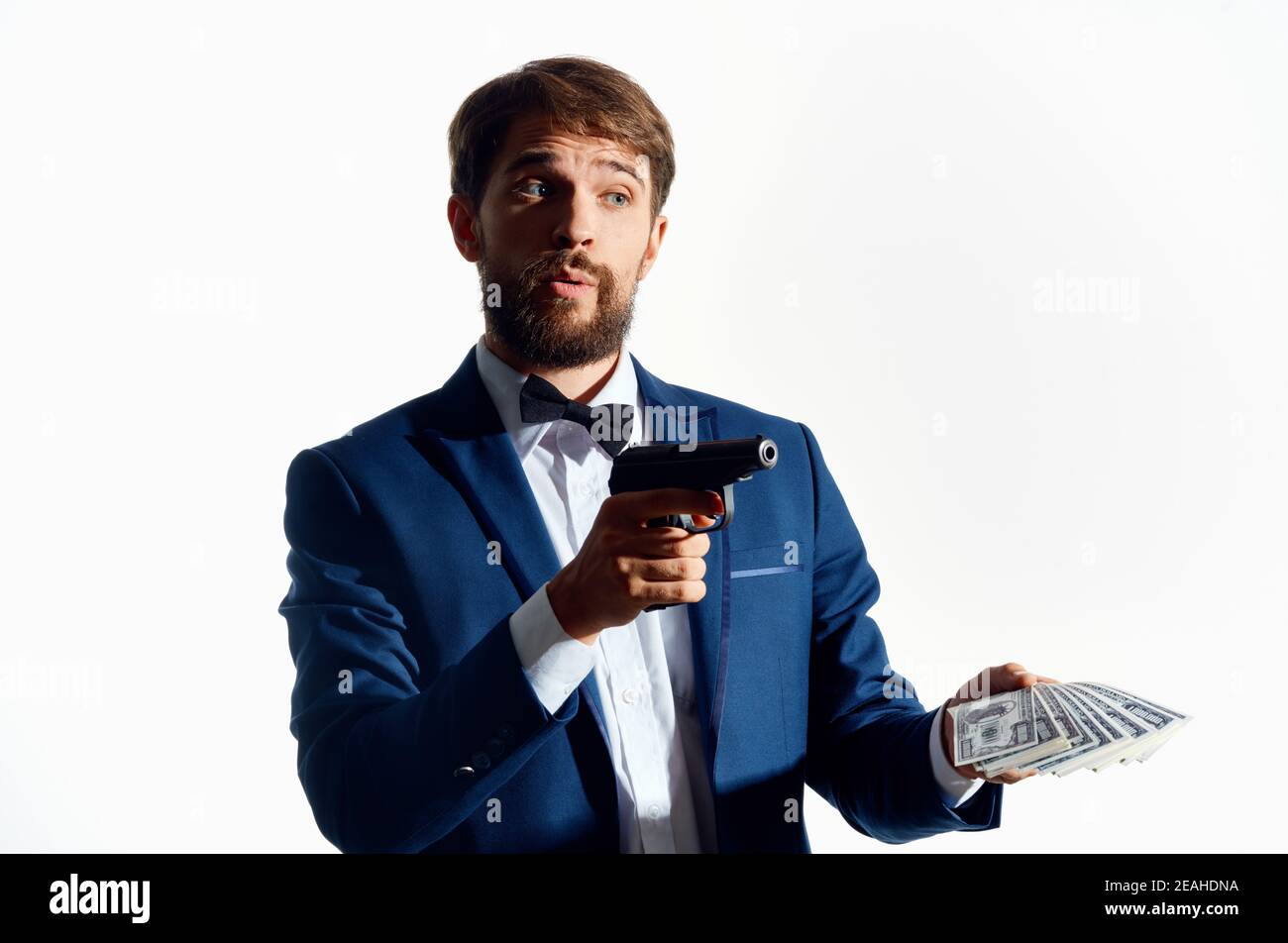 male gangster with a wad of money and a gun in hand in a classic ...