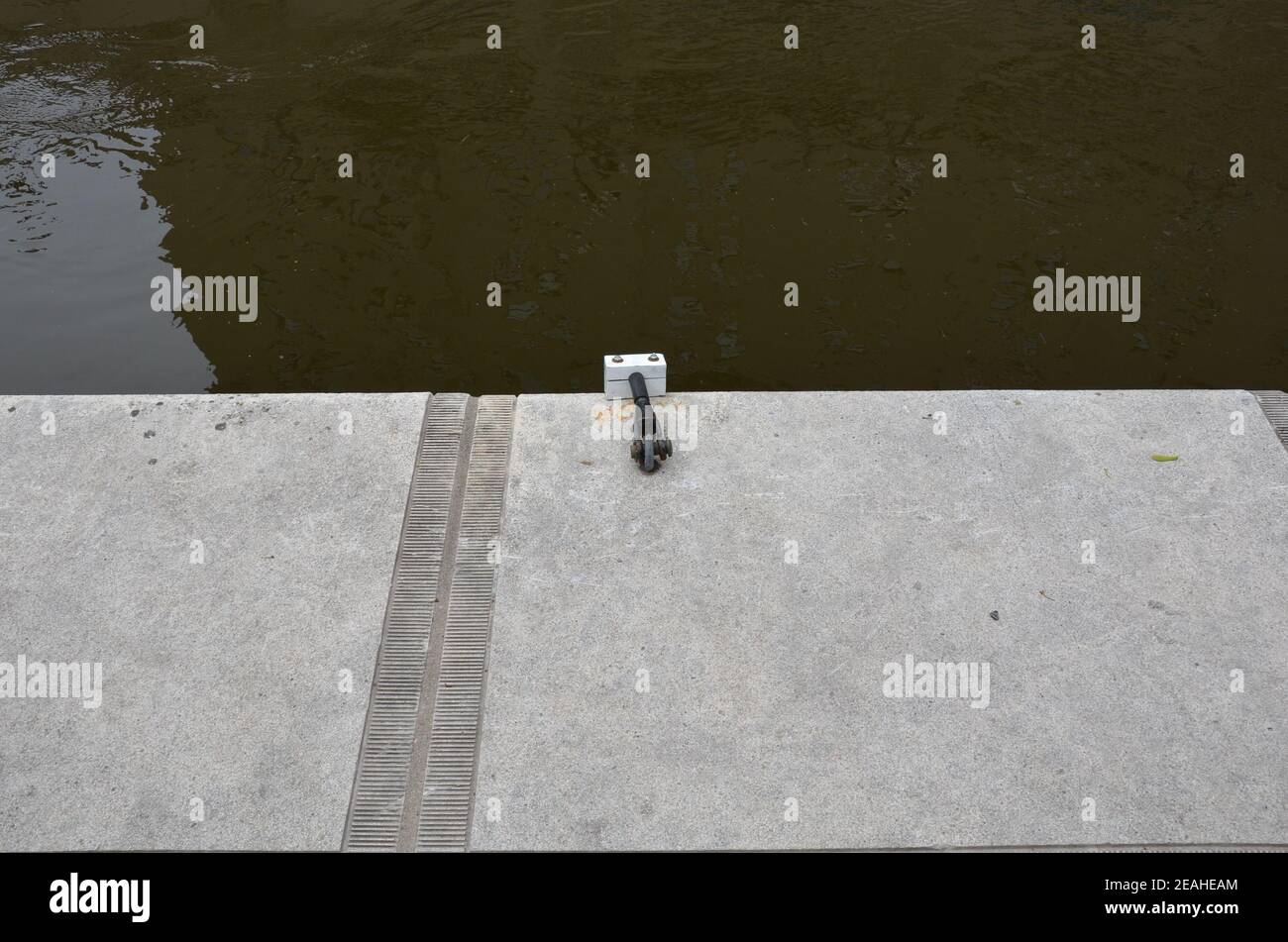 murky water in river or canal with boat tie and sidewalk Stock Photo ...