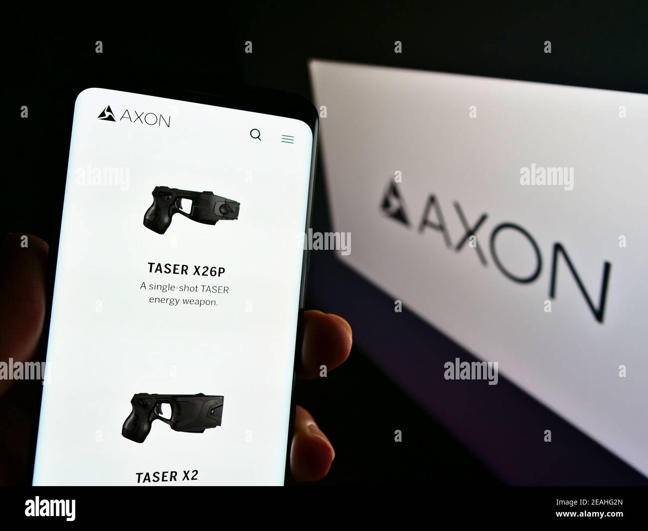 Person holding mobile phone with product web page of American weapon ...