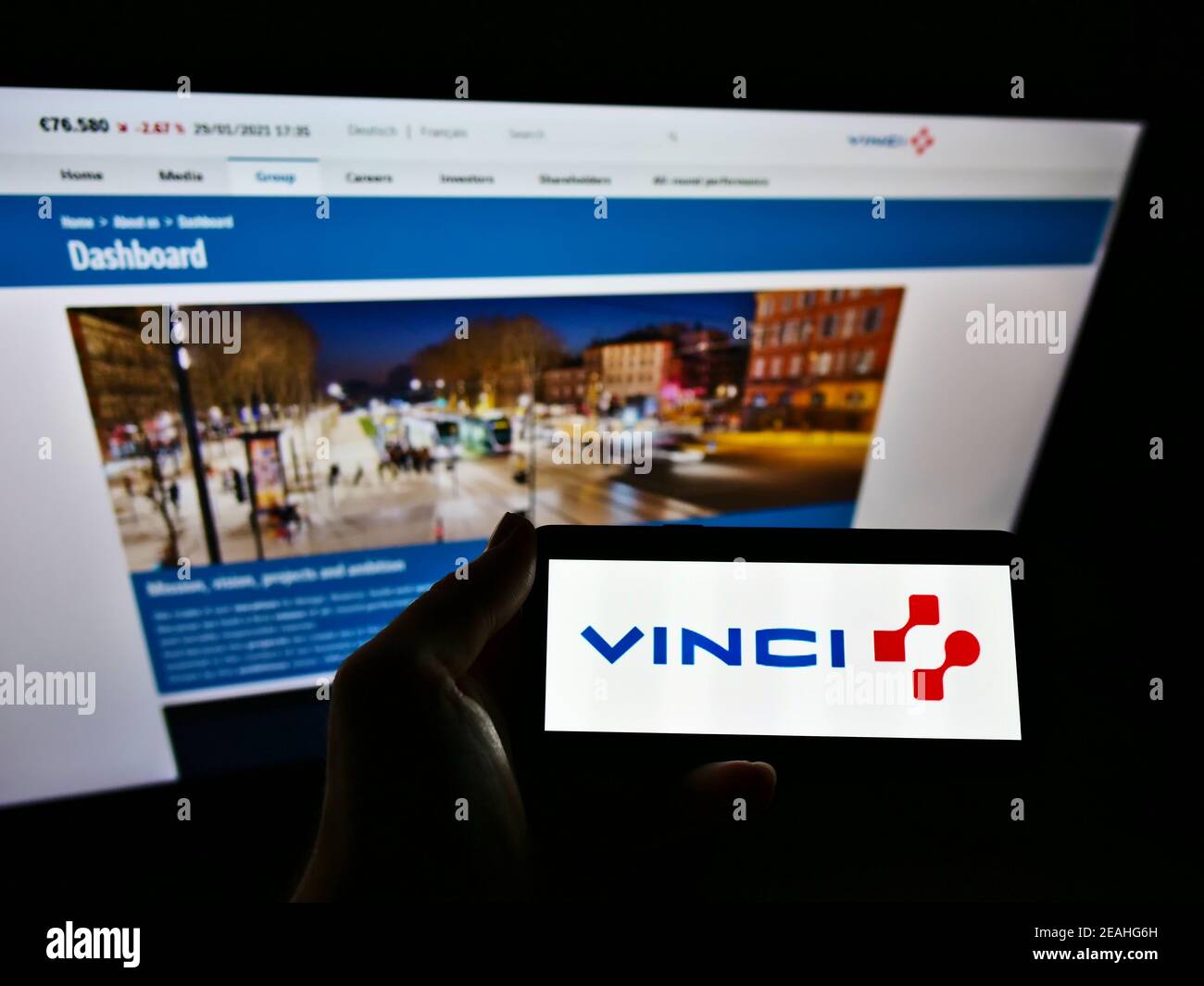 Person holding cellphone with logo of French construction company Vinci ...