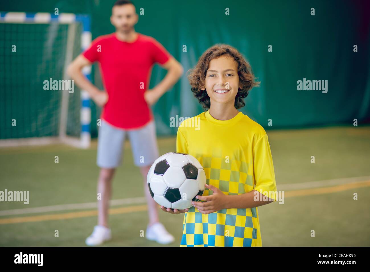 Cute boy in yellow uniform feeling good at PE lesson Stock Photo - Alamy