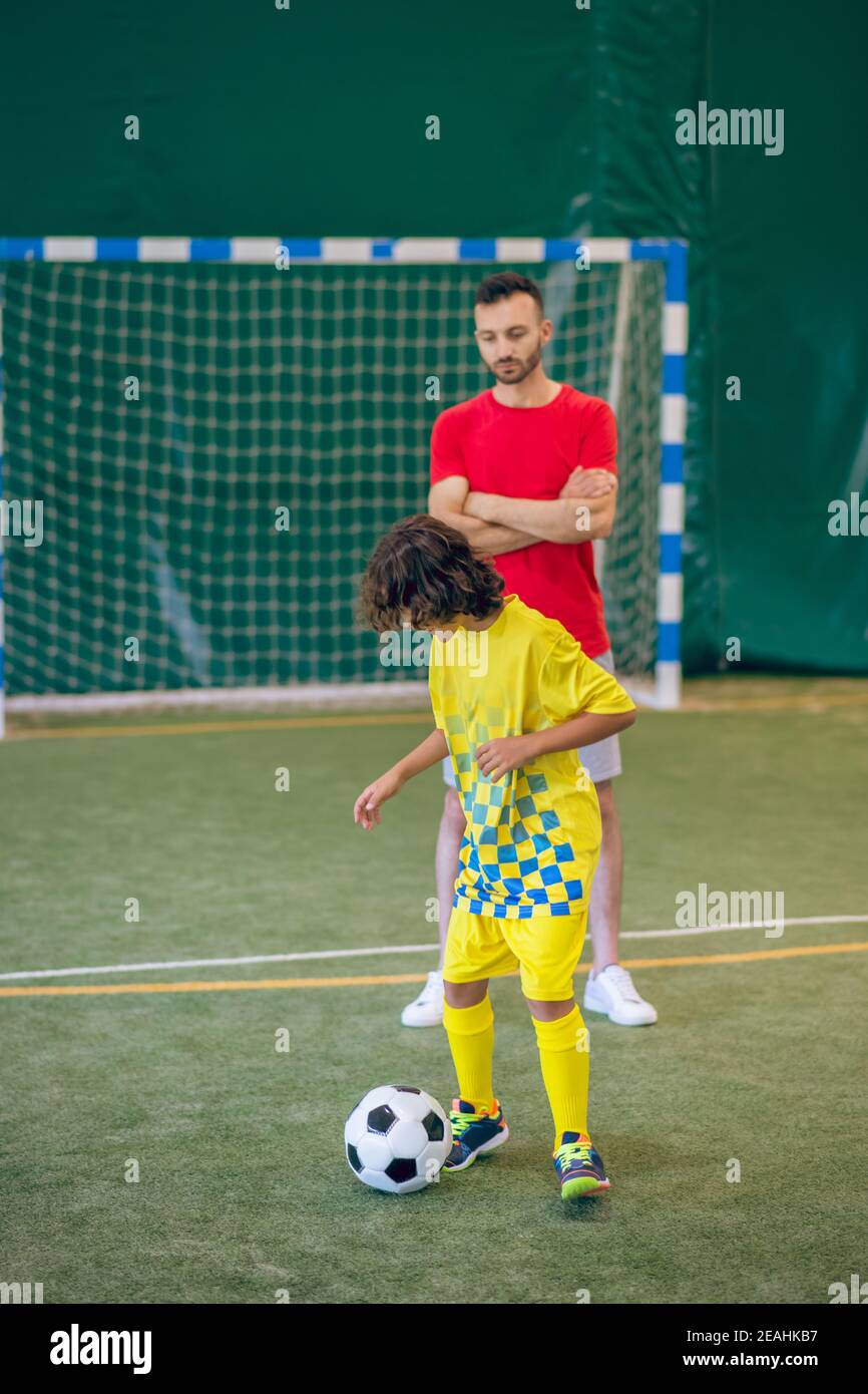 Cute boy in yellow uniform feeling good at PE lesson Stock Photo - Alamy