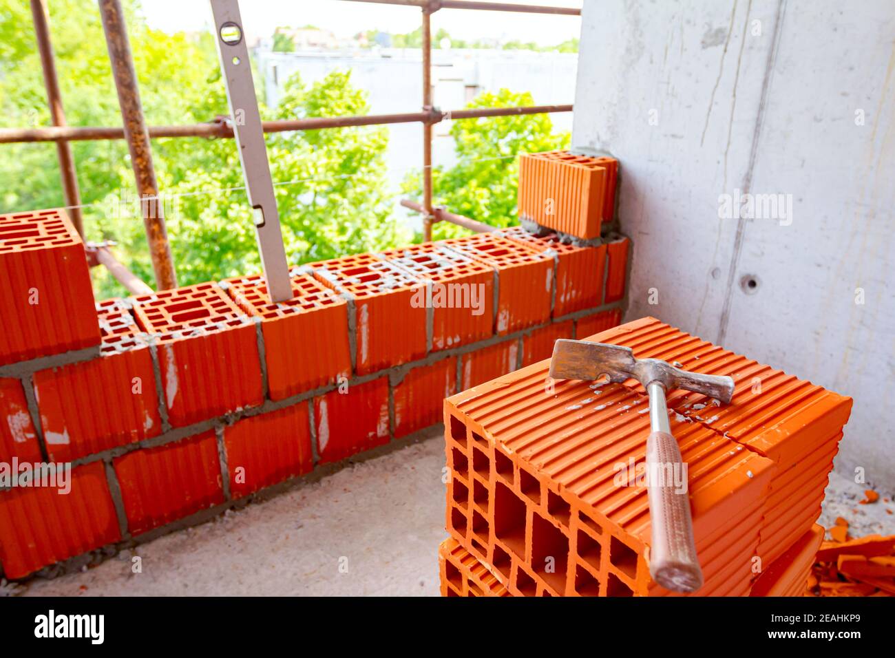 Used mason's hammer placed on pile of red ceramic blocks at ...