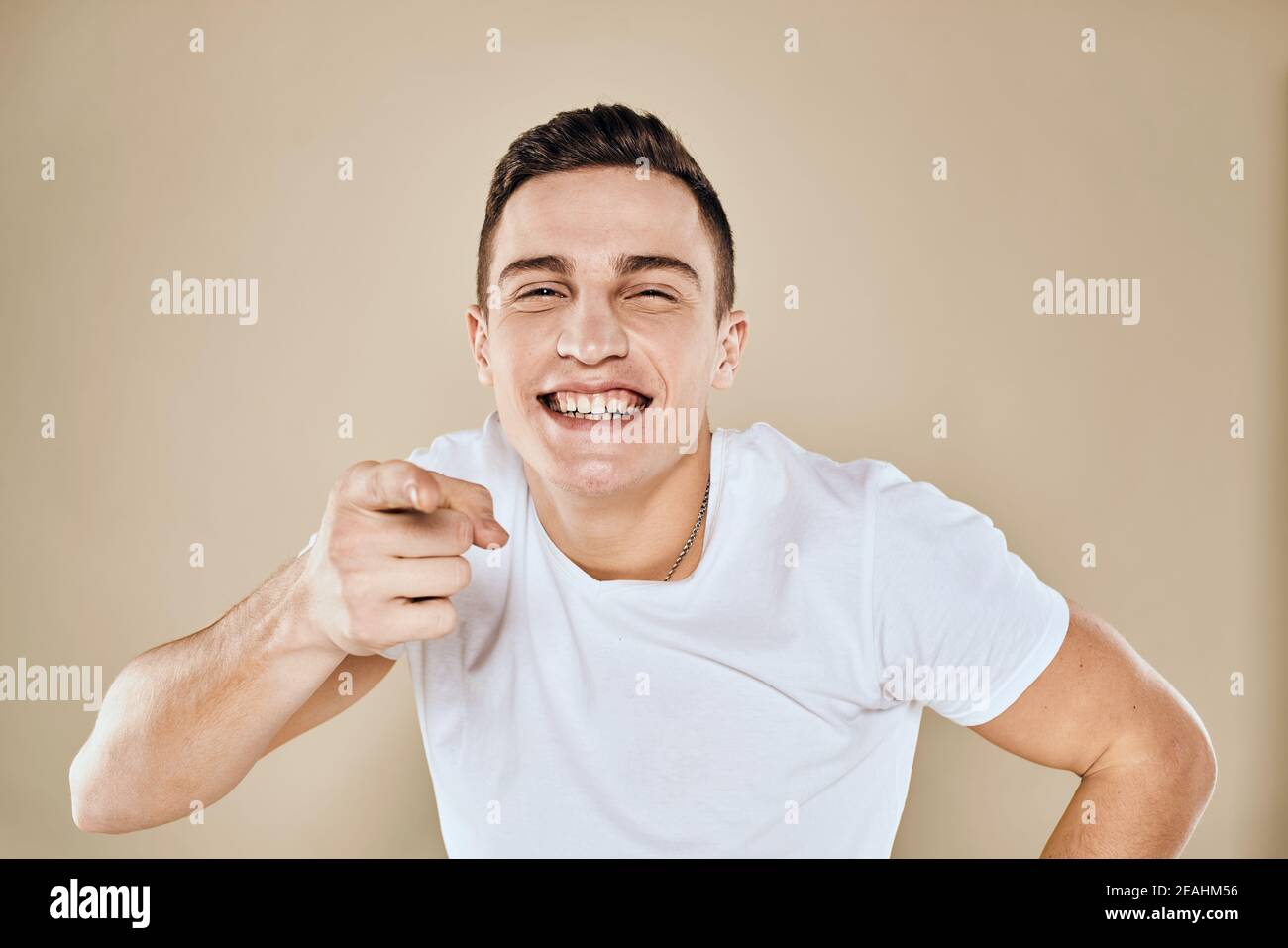 Cute emotional man white t-shirt gesture with hands cropped view beige ...