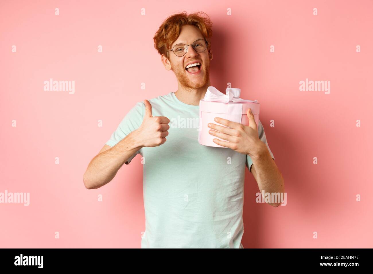 Valentines day and romance concept. Cheerful young man holding box with ...