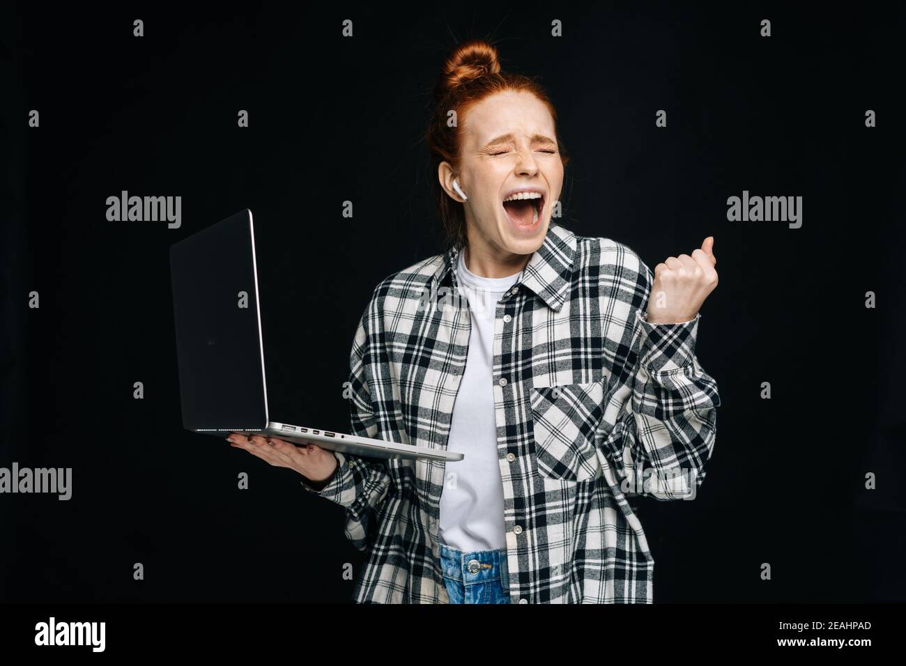Successful happy shocked young woman with open mouth and closed eyes ...