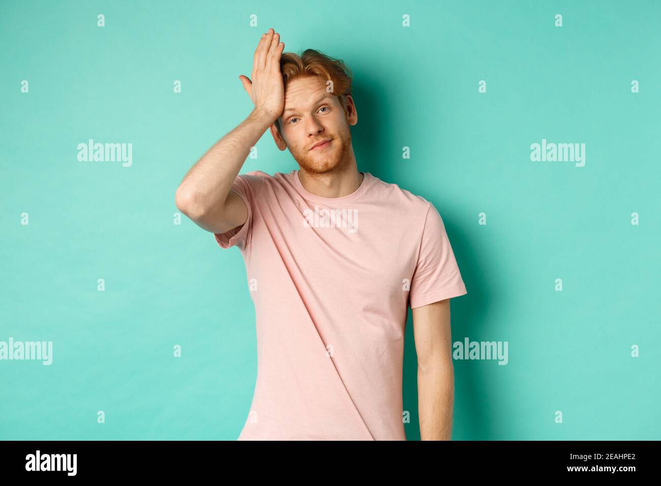 Annoyed and bothered redhead male model showing facepalm gesture ...