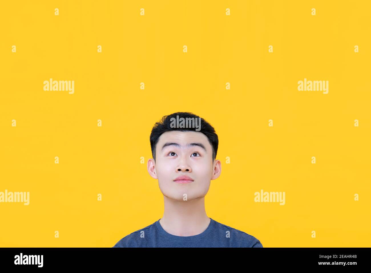 Young handsome clean shaven Asian man with thoughtful facial expression ...