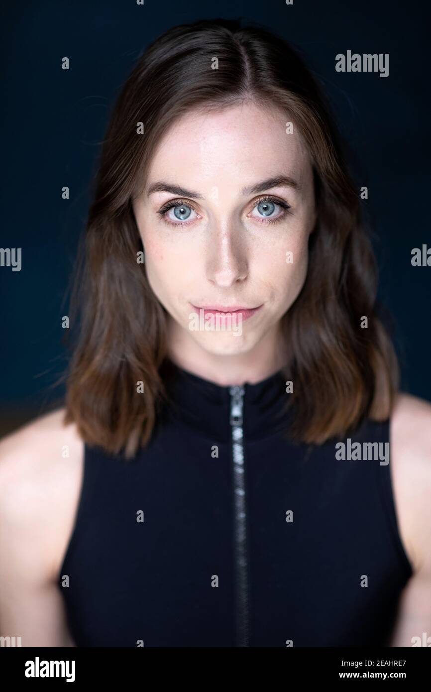Head and shoulders portrait of young woman with shoulder length brown ...