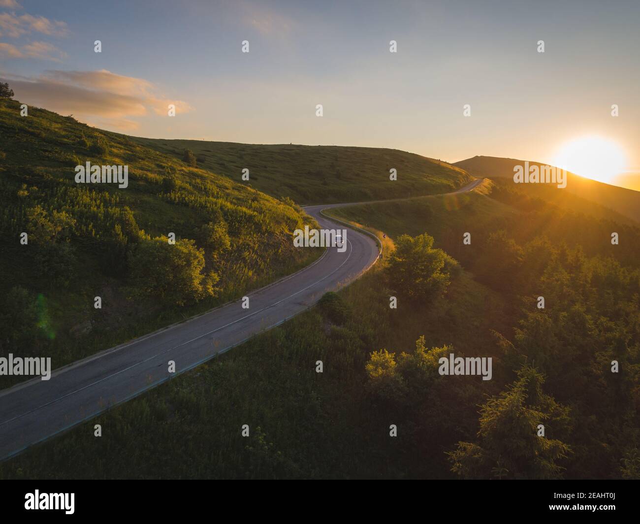Travelers driving in the mountain road at sunset Stock Photo - Alamy