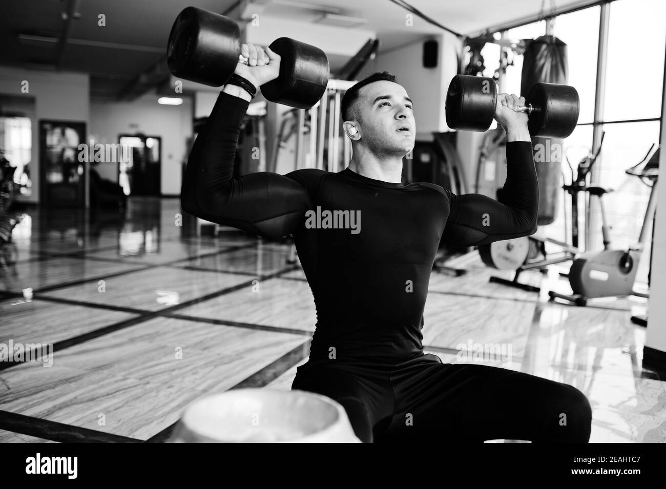 Muscular arab man training with dumbbells in modern gym Stock Photo - Alamy