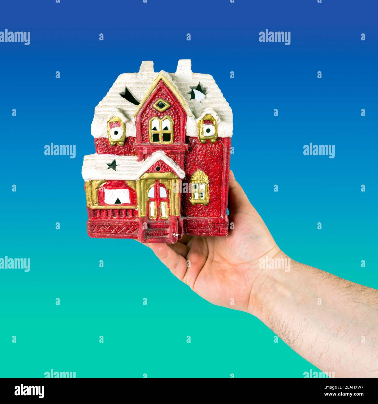 Hand holds toy house of red color Stock Photo - Alamy