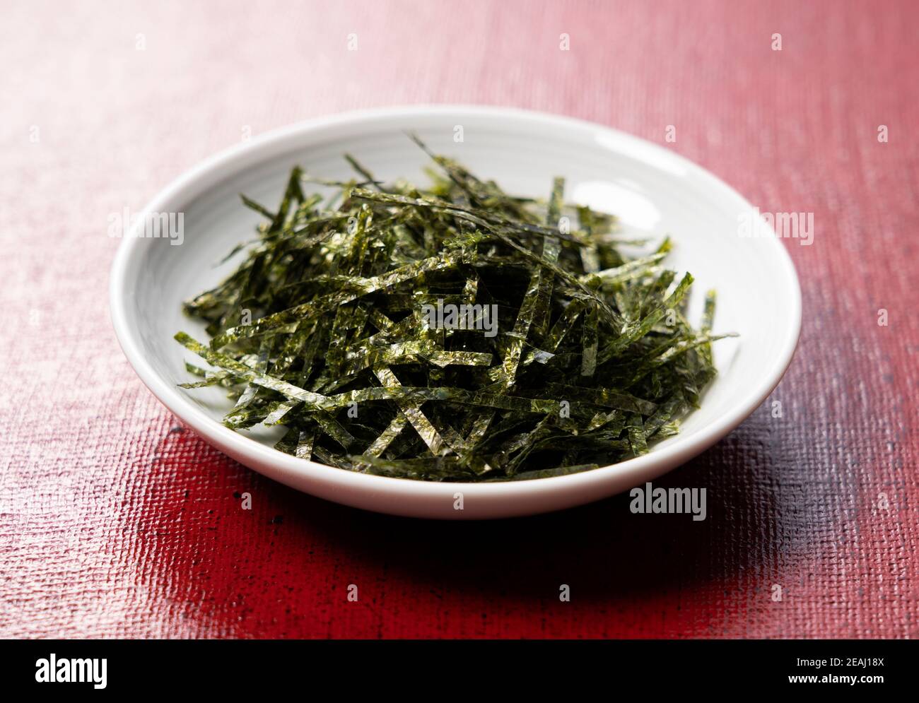 Chopped seaweed on a red Japanese background Stock Photo - Alamy