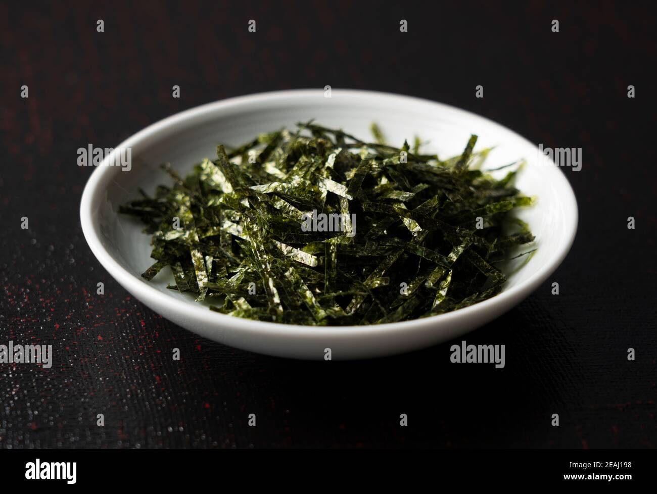 Chopped seaweed on a black background Stock Photo - Alamy