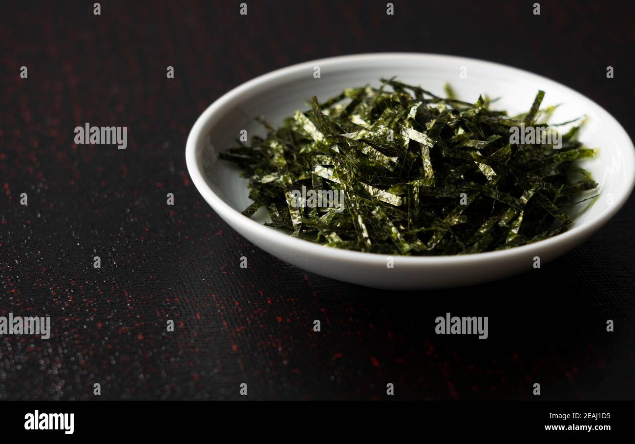 Chopped seaweed on a black background Stock Photo - Alamy
