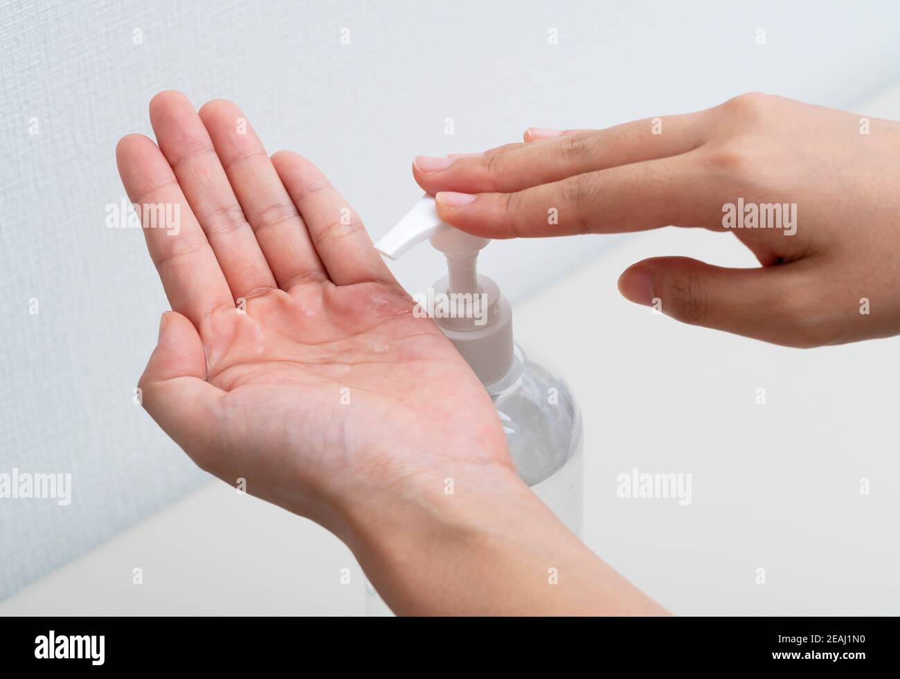 Women's hands using sanitizing gel Stock Photo - Alamy