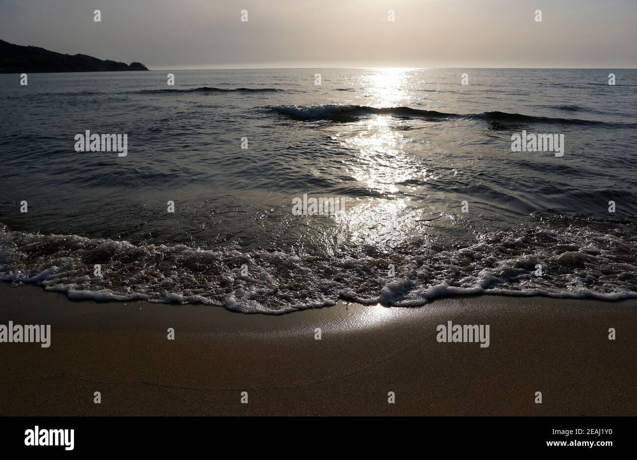 The beach with the evening sun shining in Stock Photo - Alamy