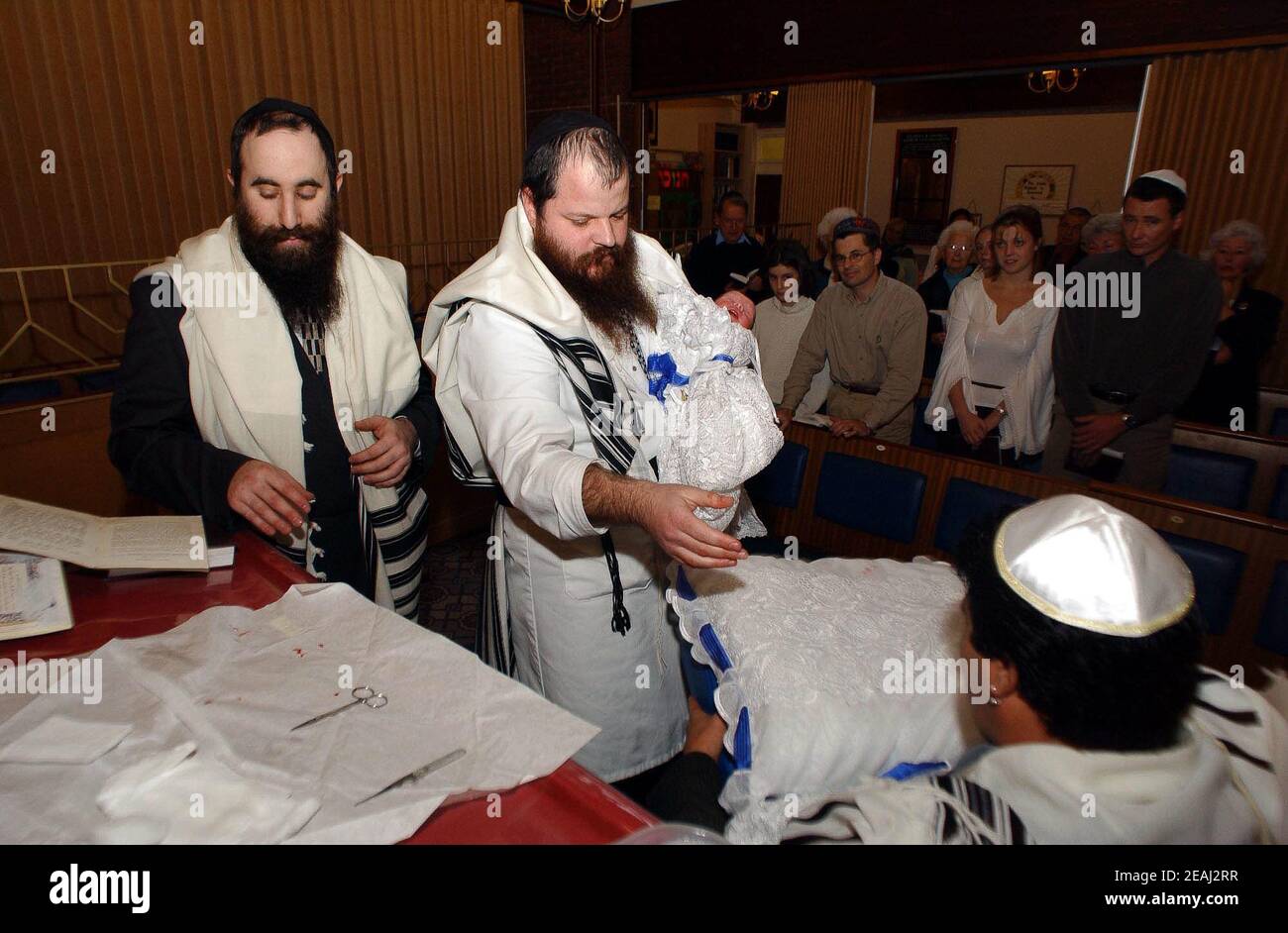 A Brit Milah ceremony takes place on the bimah of the synagogue in the ...