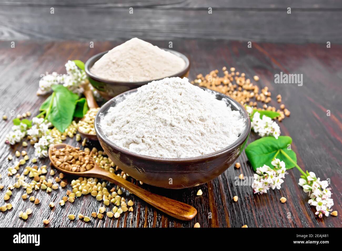 Flour buckwheat green and brown in bowls with flowers on board Stock ...