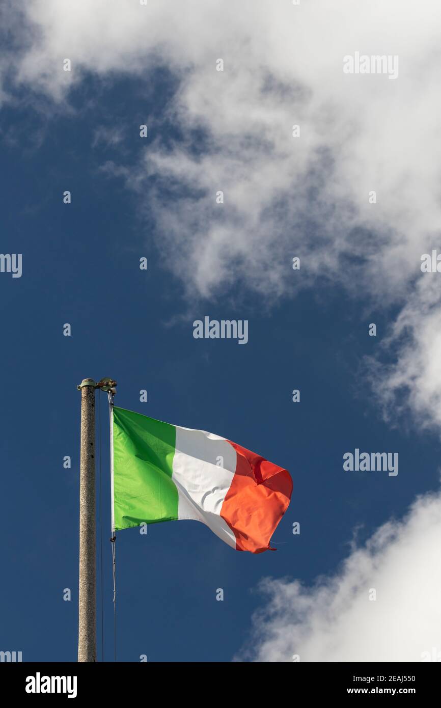 Italian flag blowing in the wind in the blue sky Stock Photo - Alamy