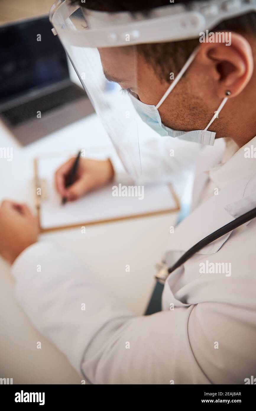 Physician writing in notepad hi-res stock photography and images - Alamy