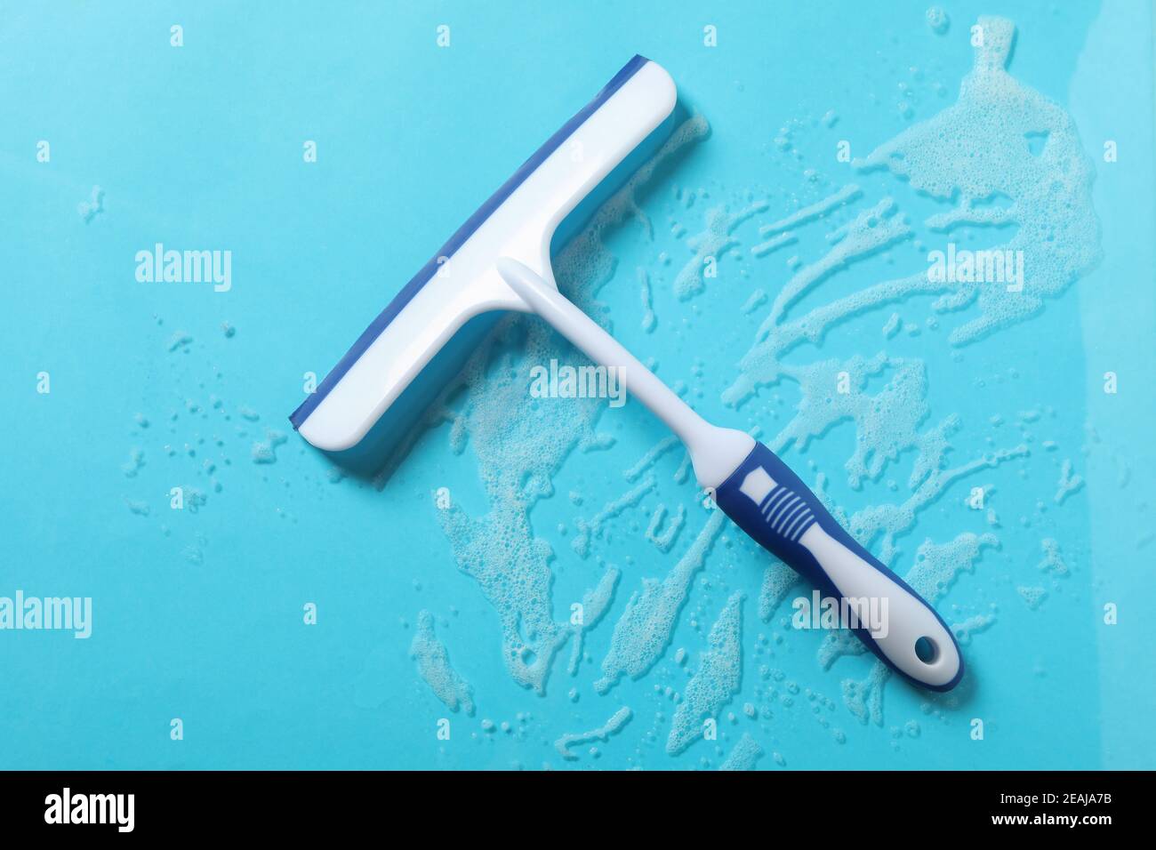 Window сleaning squeegee on blue background with foam Stock Photo - Alamy