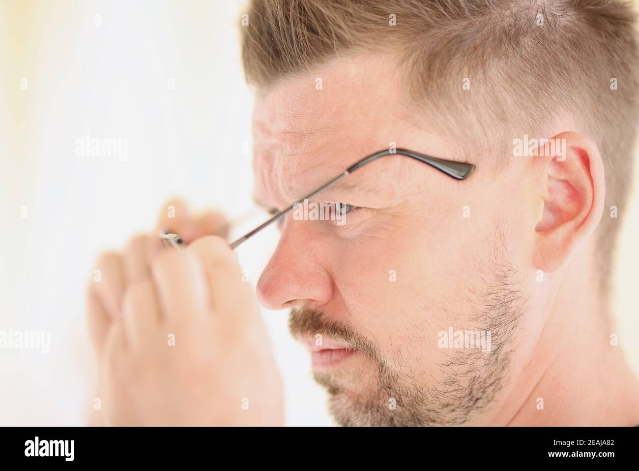 Portrait of concentrated male male taking off his glasses Stock Photo ...