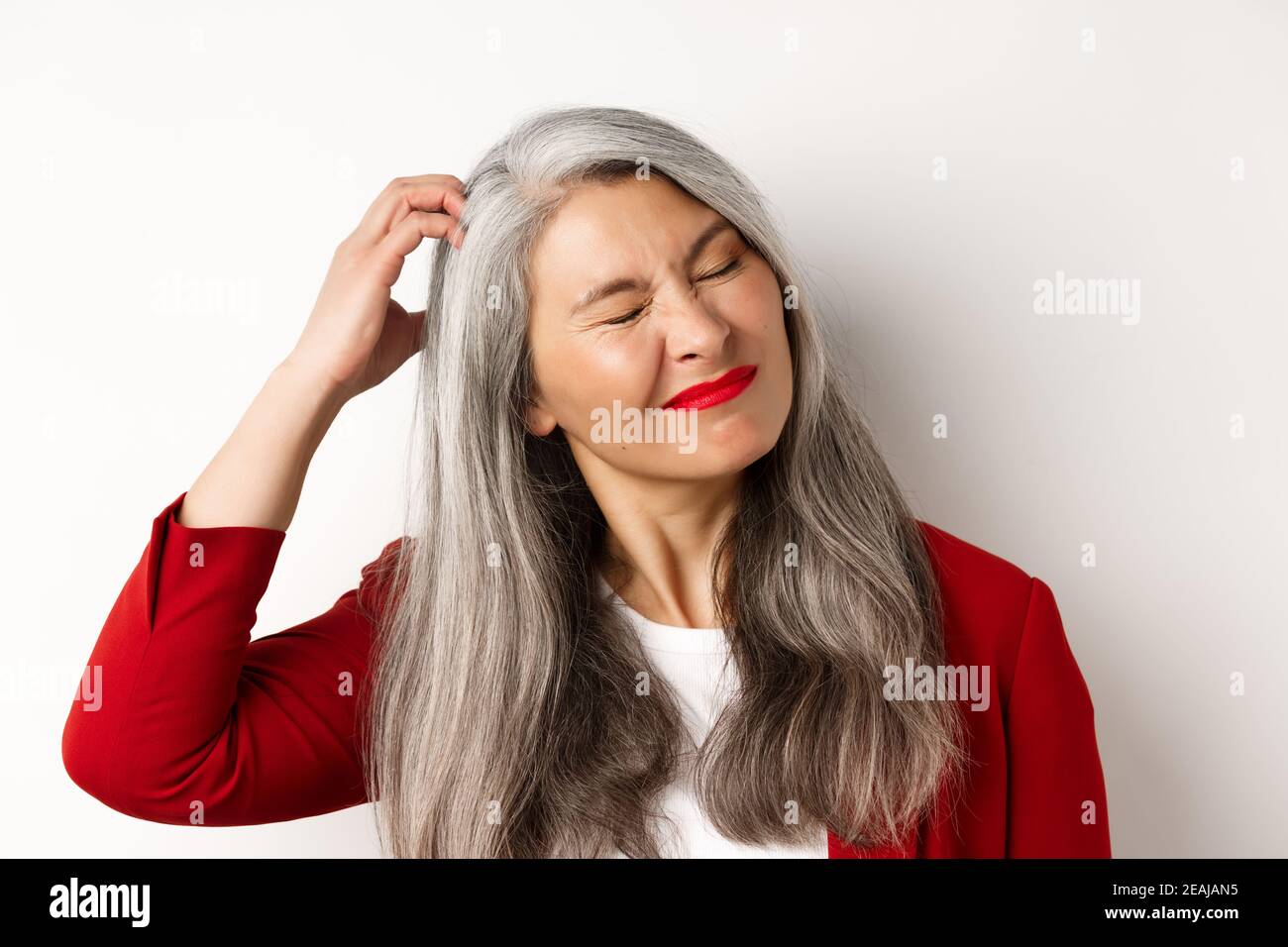 Close up of senior asian woman scratching head and looking bothered by ...