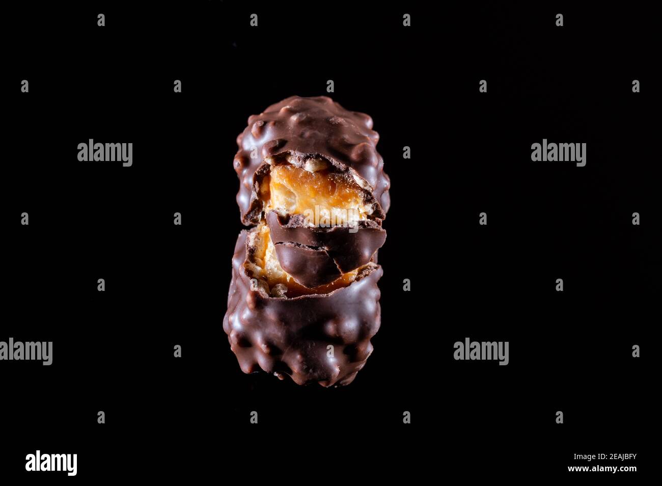 Chocolate candy with caramel and nuts. Broken candy into pieces ...