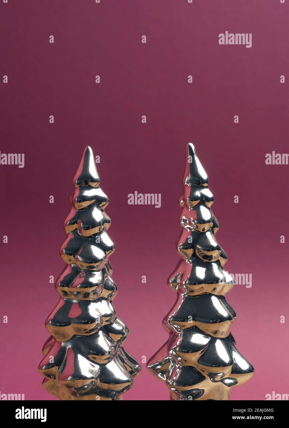 Two silver trees with snow on a red paper background, space for text on ...