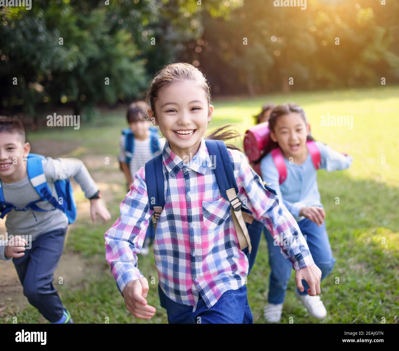 Group of elementary school kids running on the grass Stock Photo - Alamy