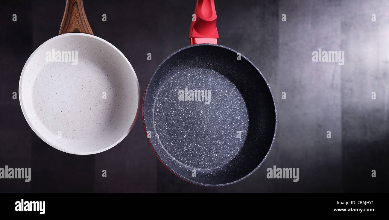 Two hanging stainless frying pans Stock Photo - Alamy