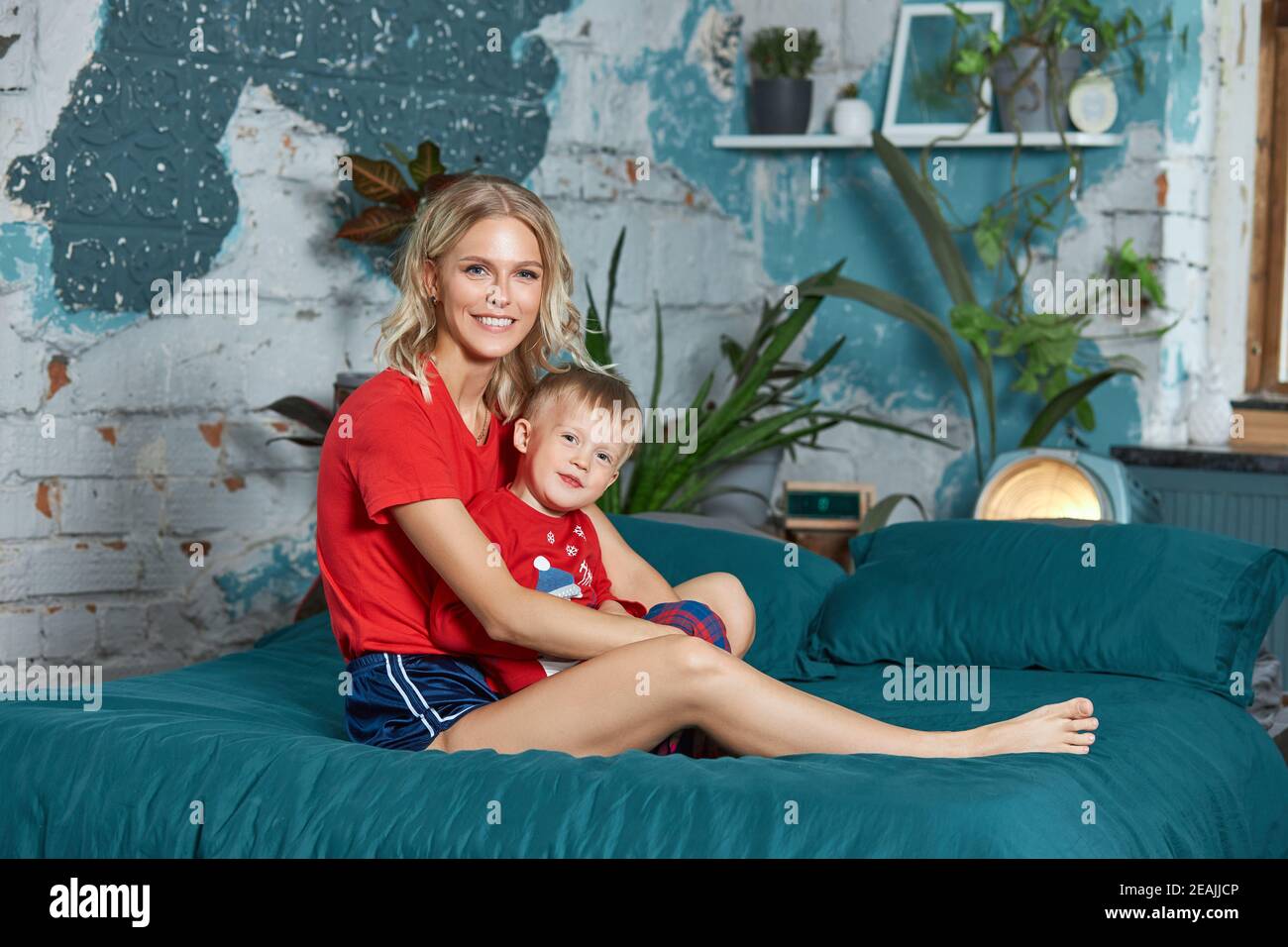 Young mother plays and hugs her son. Day off at home, a smile on your ...