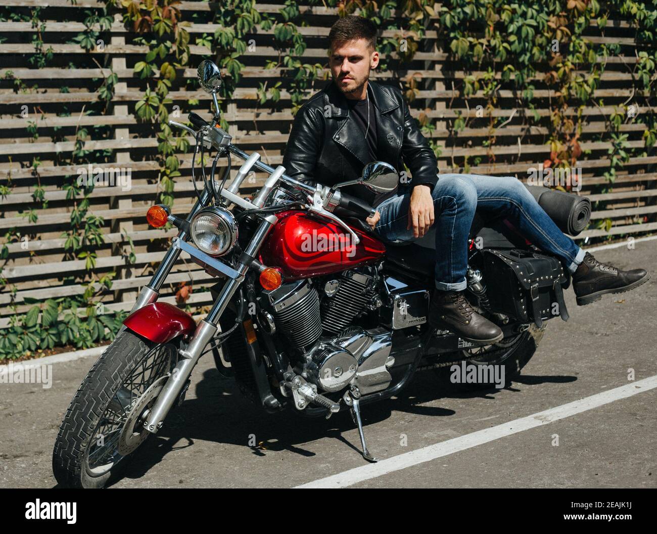 Young motorcyclist sitting on a classic motorcycle Stock Photo - Alamy