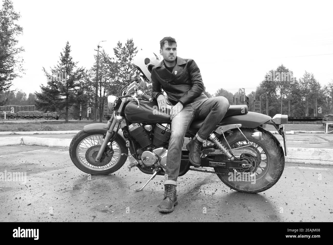 Young motorcyclist sitting on a classic motorcycle Stock Photo - Alamy