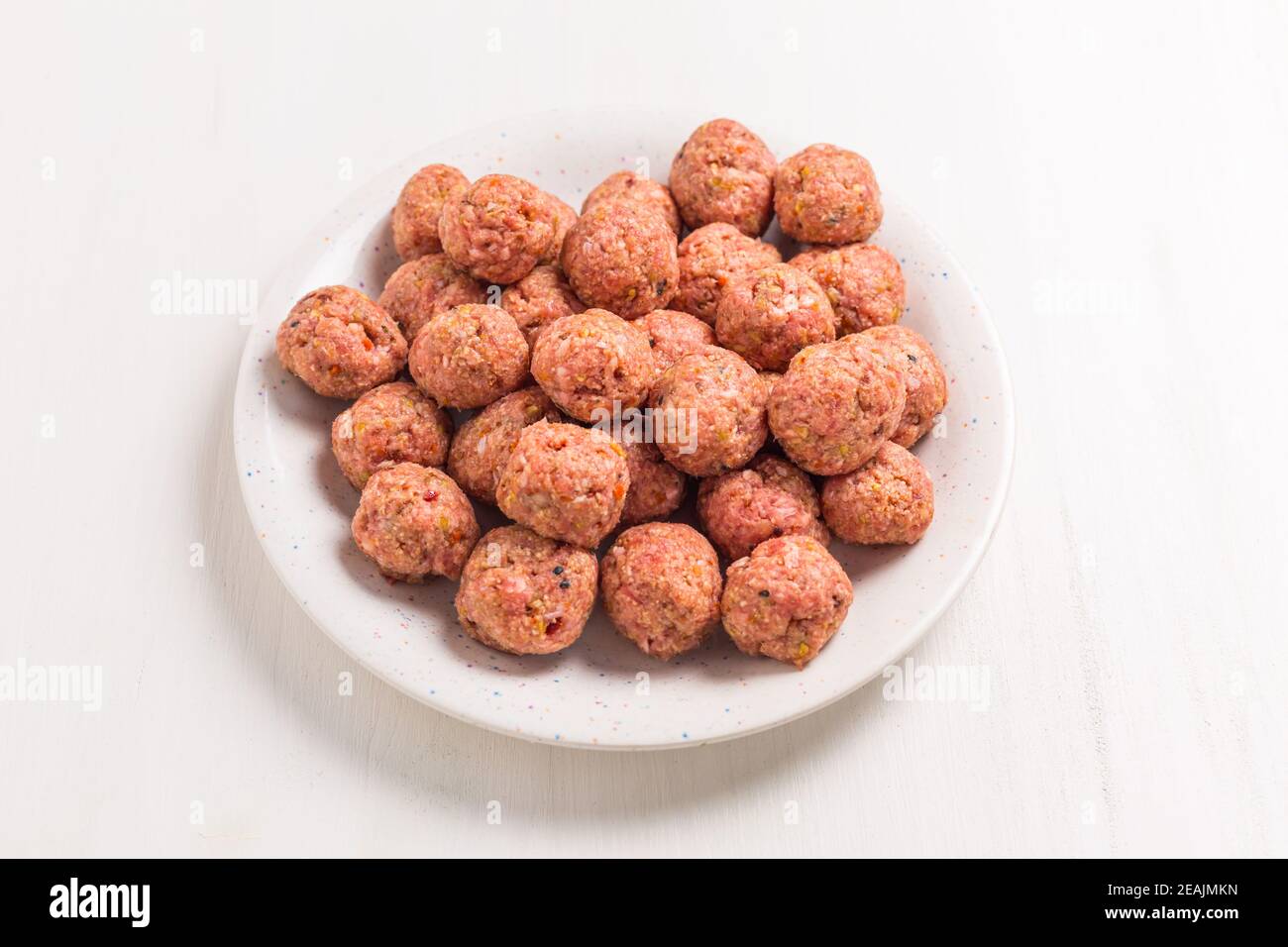 Raw meatballs on plate and white background Stock Photo - Alamy