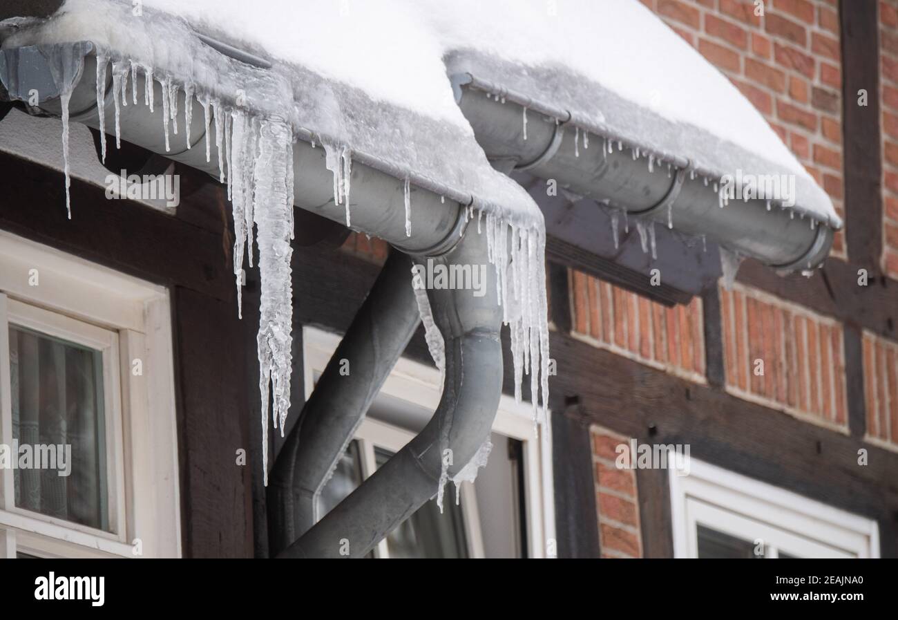 Peine, Germany. 10th Feb, 2021. Icicles hang from the roof of a house ...