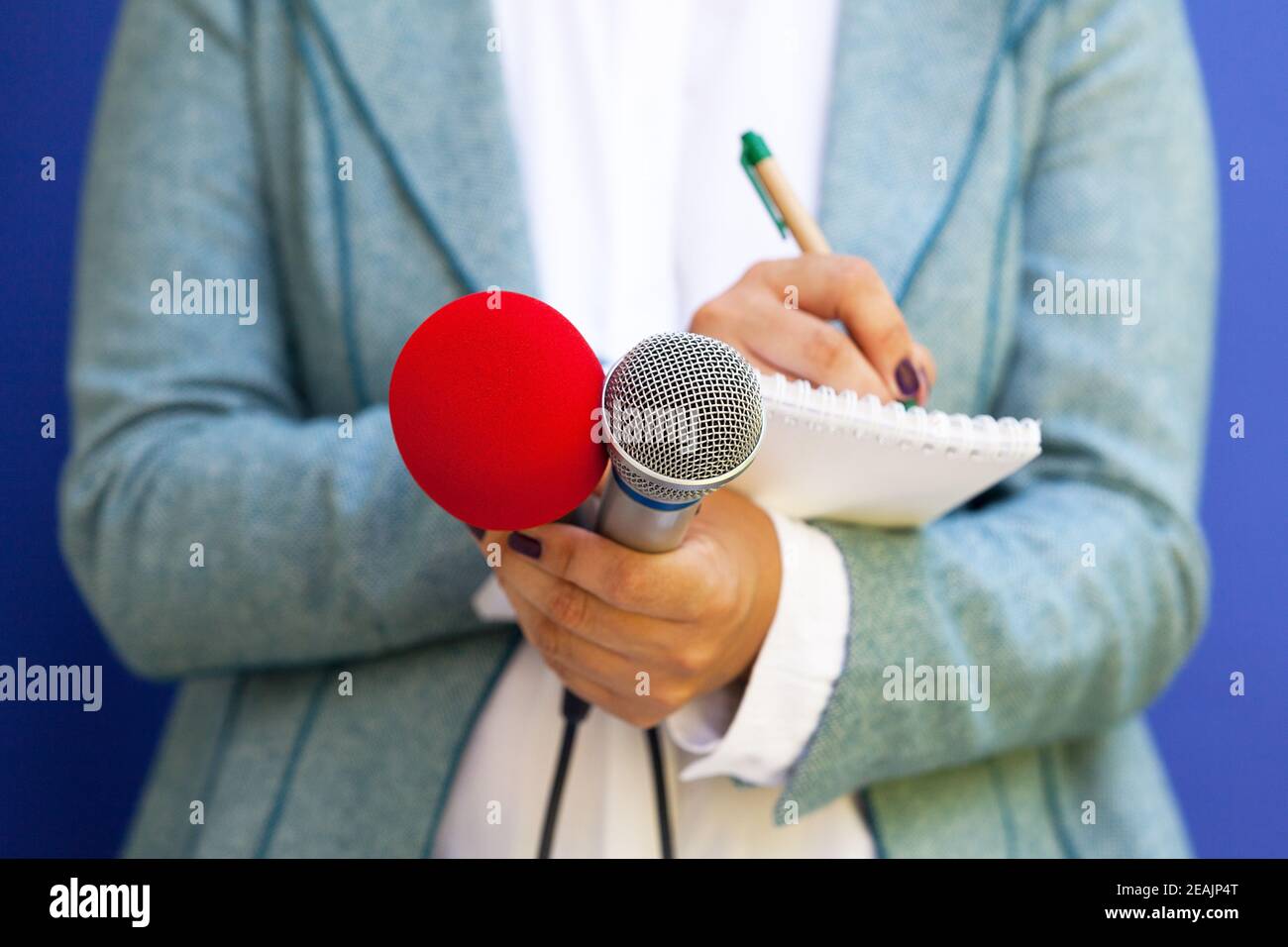 Journalist at press conference, taking notes, holding microphone Stock ...