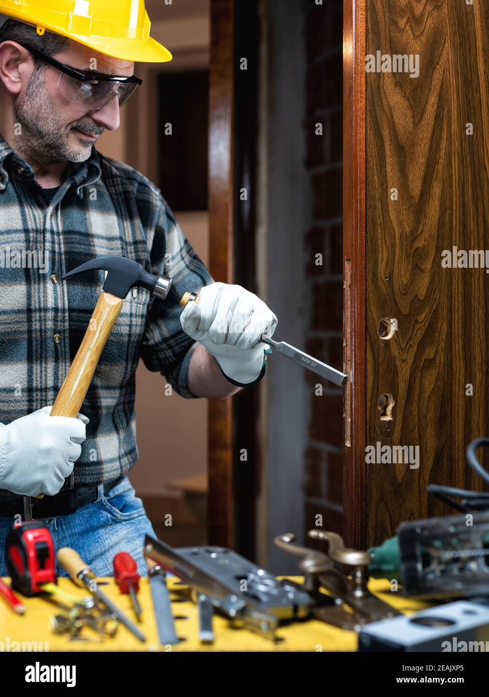 Carpenter at work repairs and installs the door lock. Carpentry Stock ...