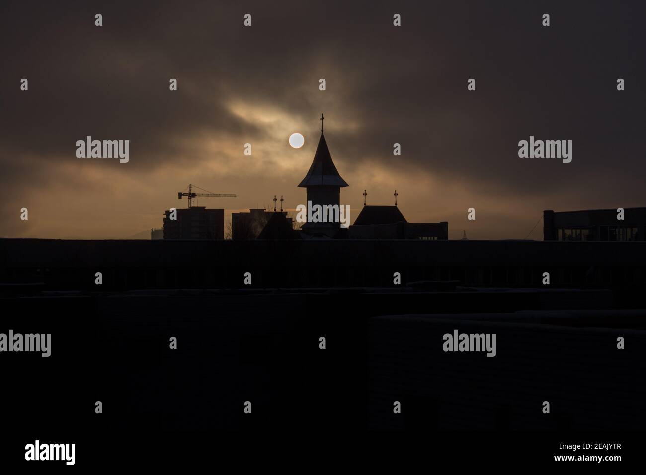 Fade sunrise with fog and dark sky with silhouette church and buildings ...