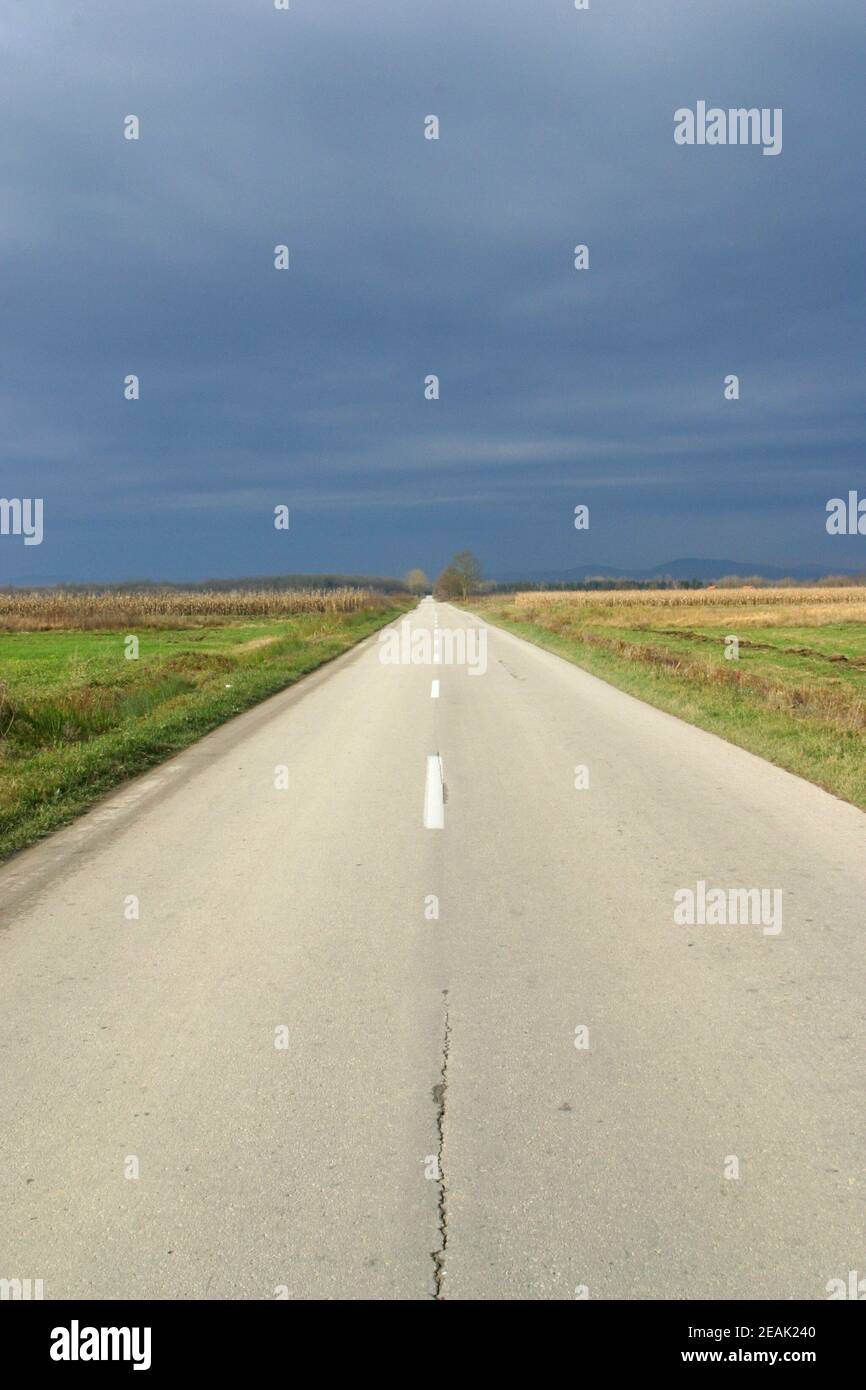 Empty road in autumn day between meadows and fields Stock Photo - Alamy