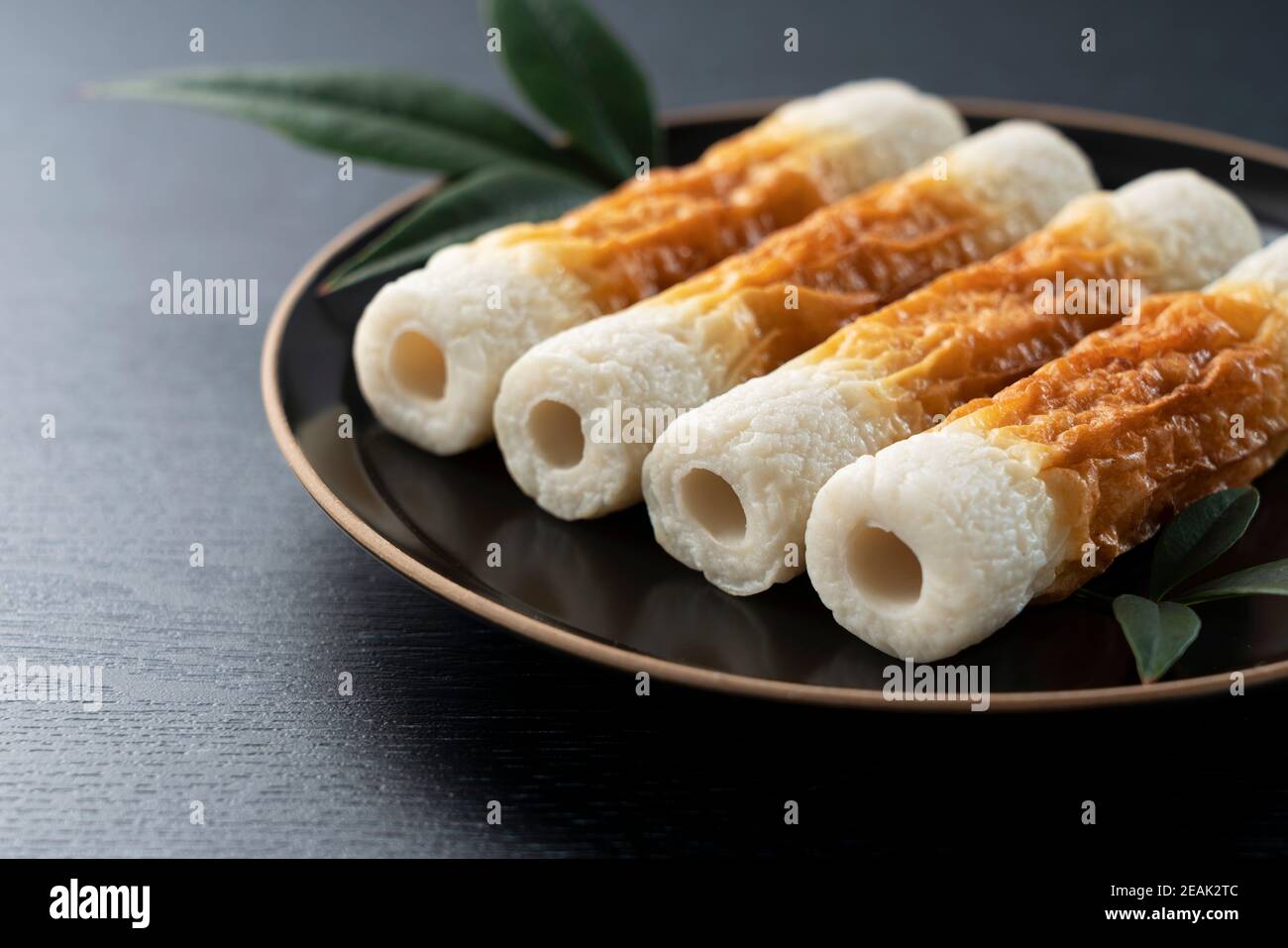 Japanese chikuwa placed on a black background Stock Photo - Alamy