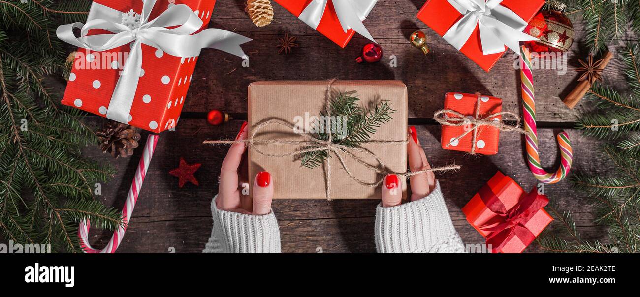 Woman holding a gift box in a gesture of giving Stock Photo - Alamy