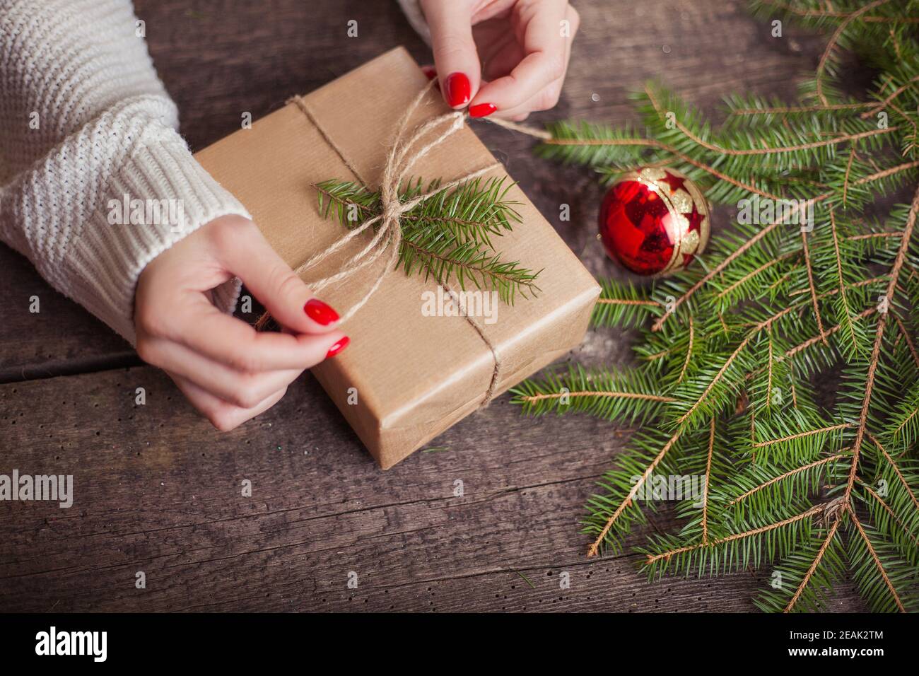 Woman holding a gift box in a gesture of giving Stock Photo - Alamy