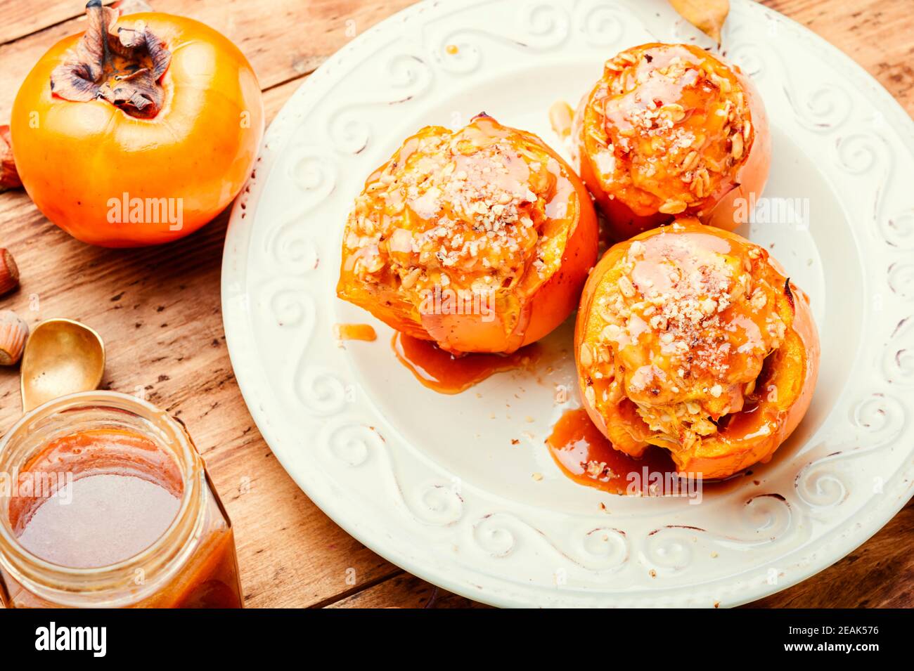 Baked persimmon with granola Stock Photo - Alamy