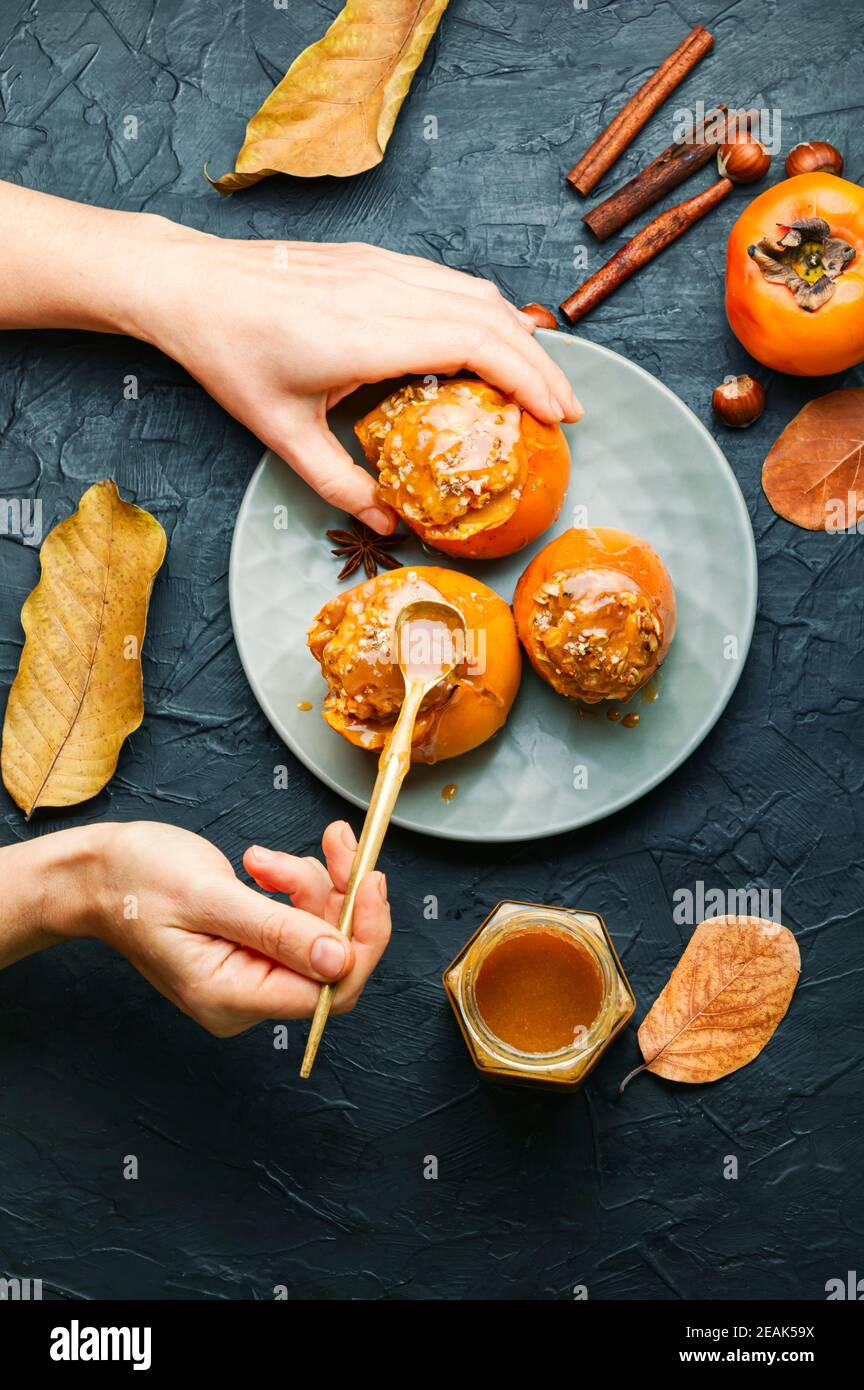 Baked persimmon with granola Stock Photo - Alamy