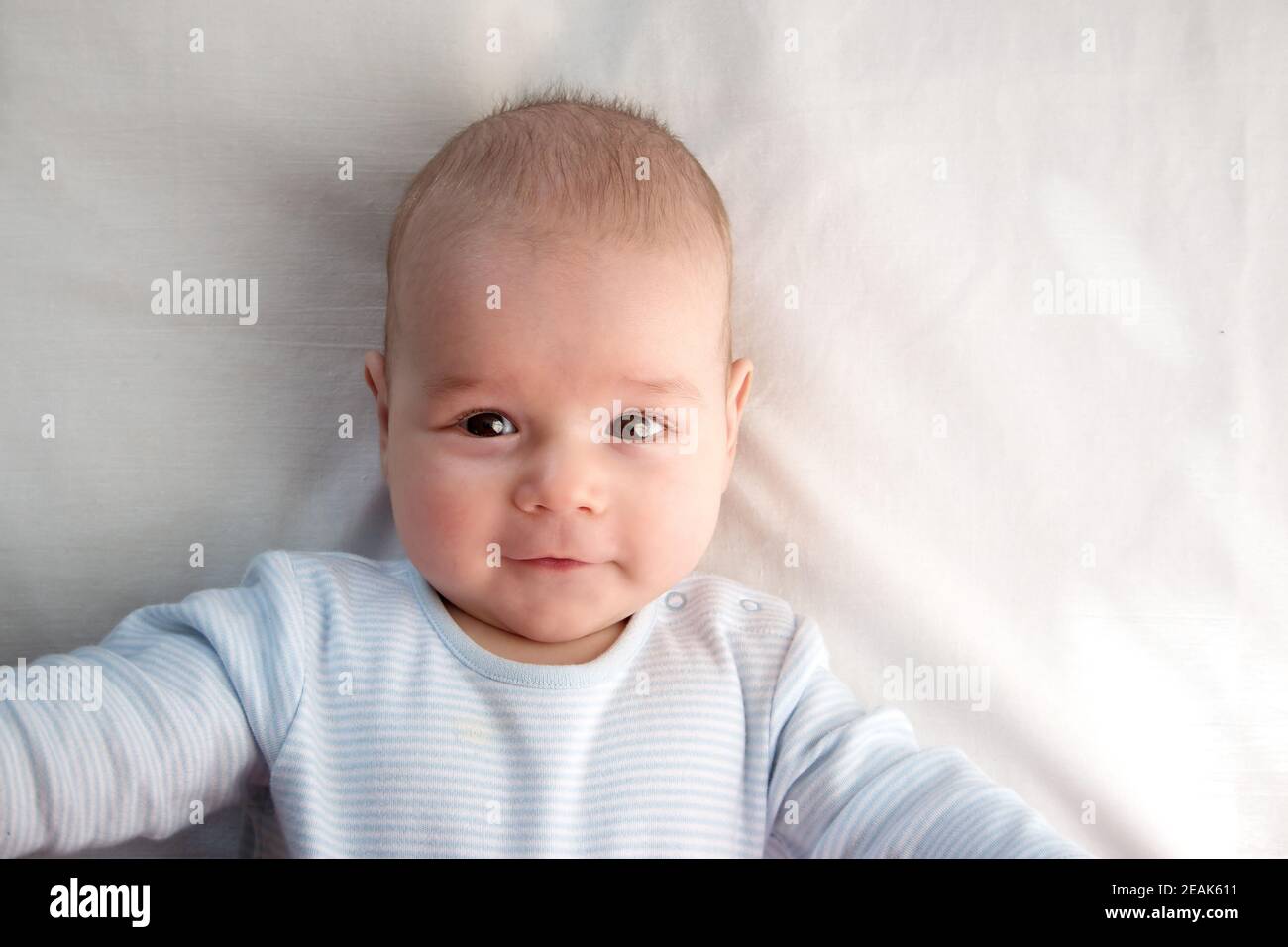 three month old baby wrapped in blue blanket Stock Photo - Alamy