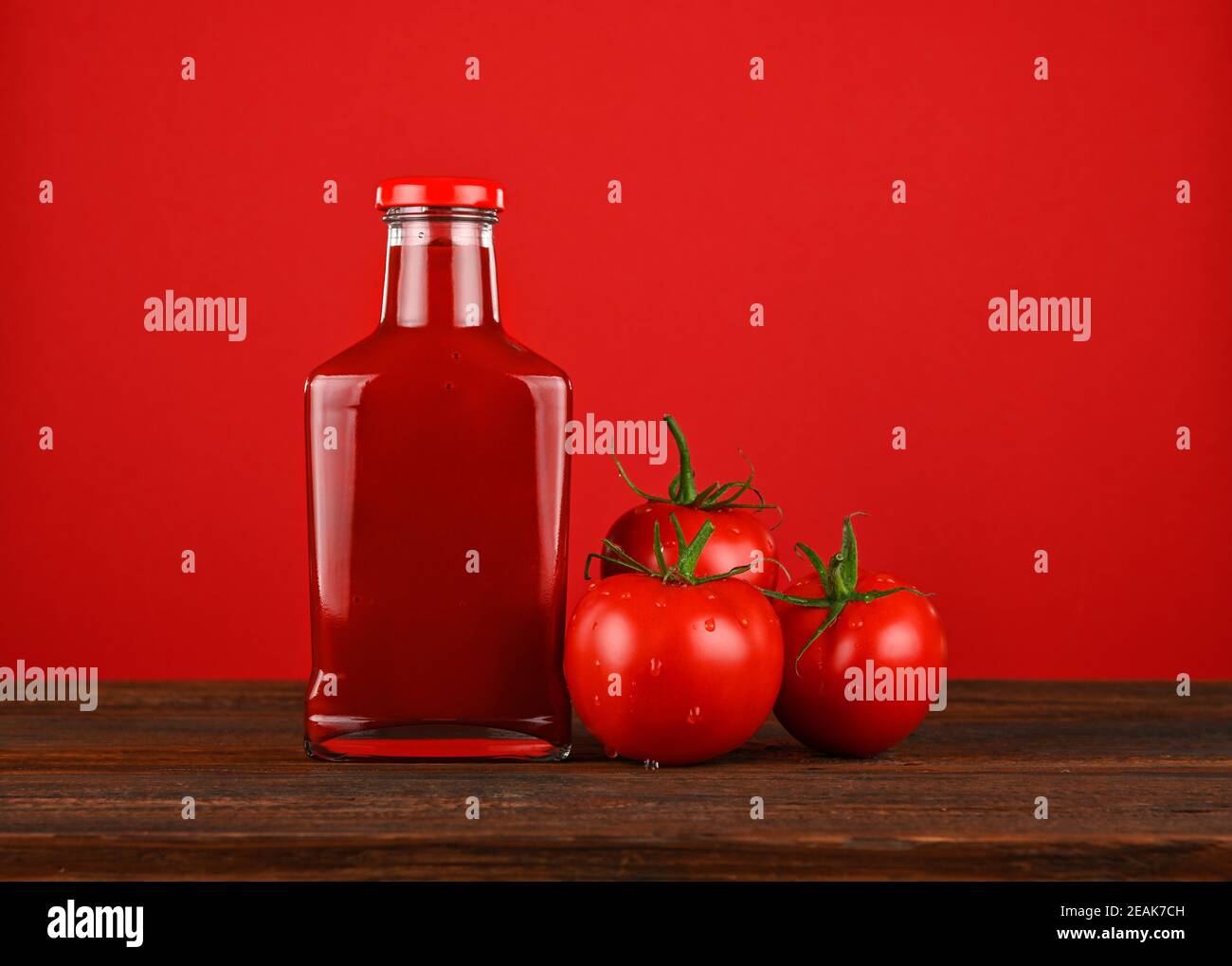 Bottle of ketchup and fresh tomatoes over red Stock Photo - Alamy