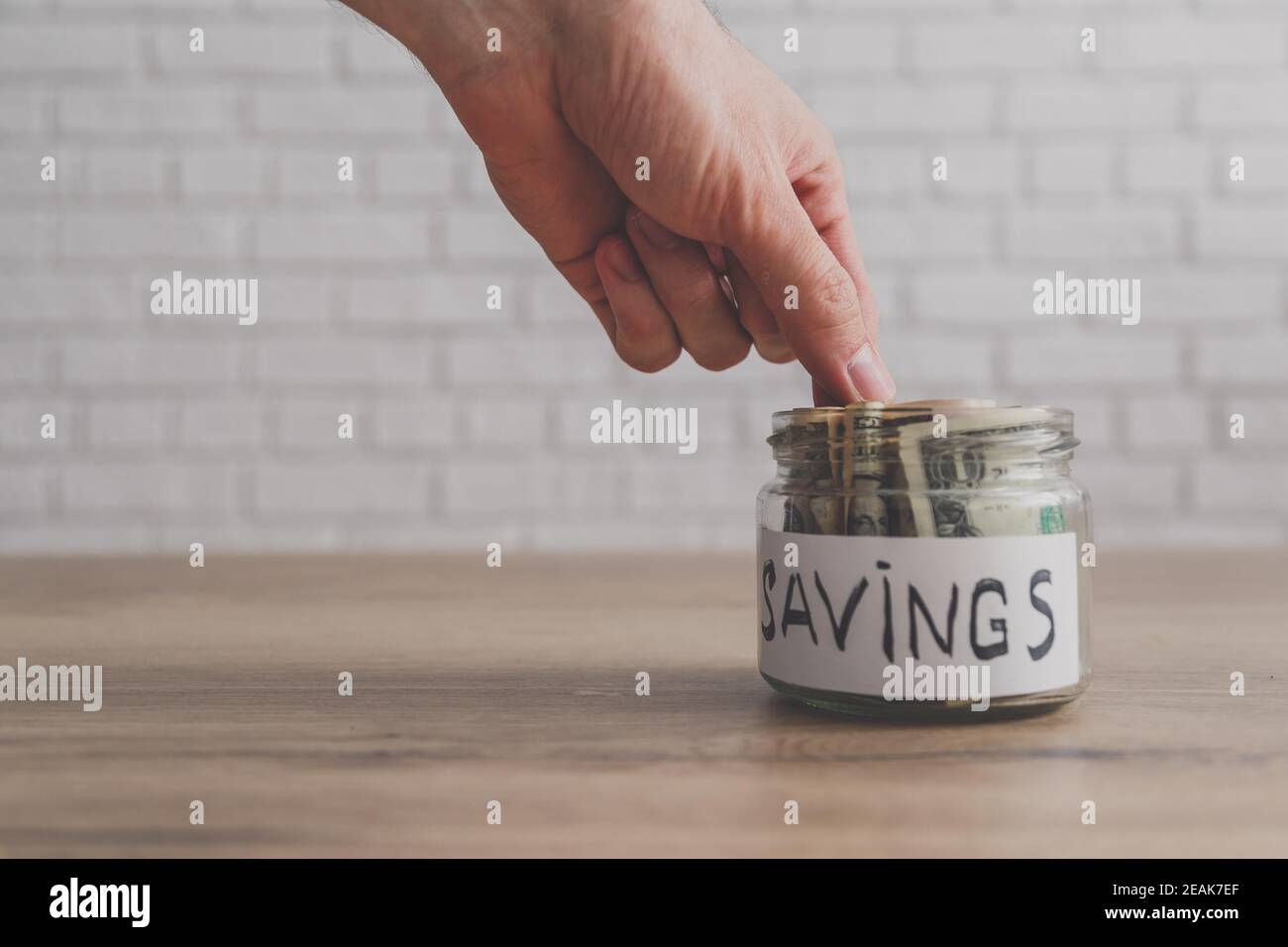 Hand put or take money from glass jar on white background Stock Photo ...