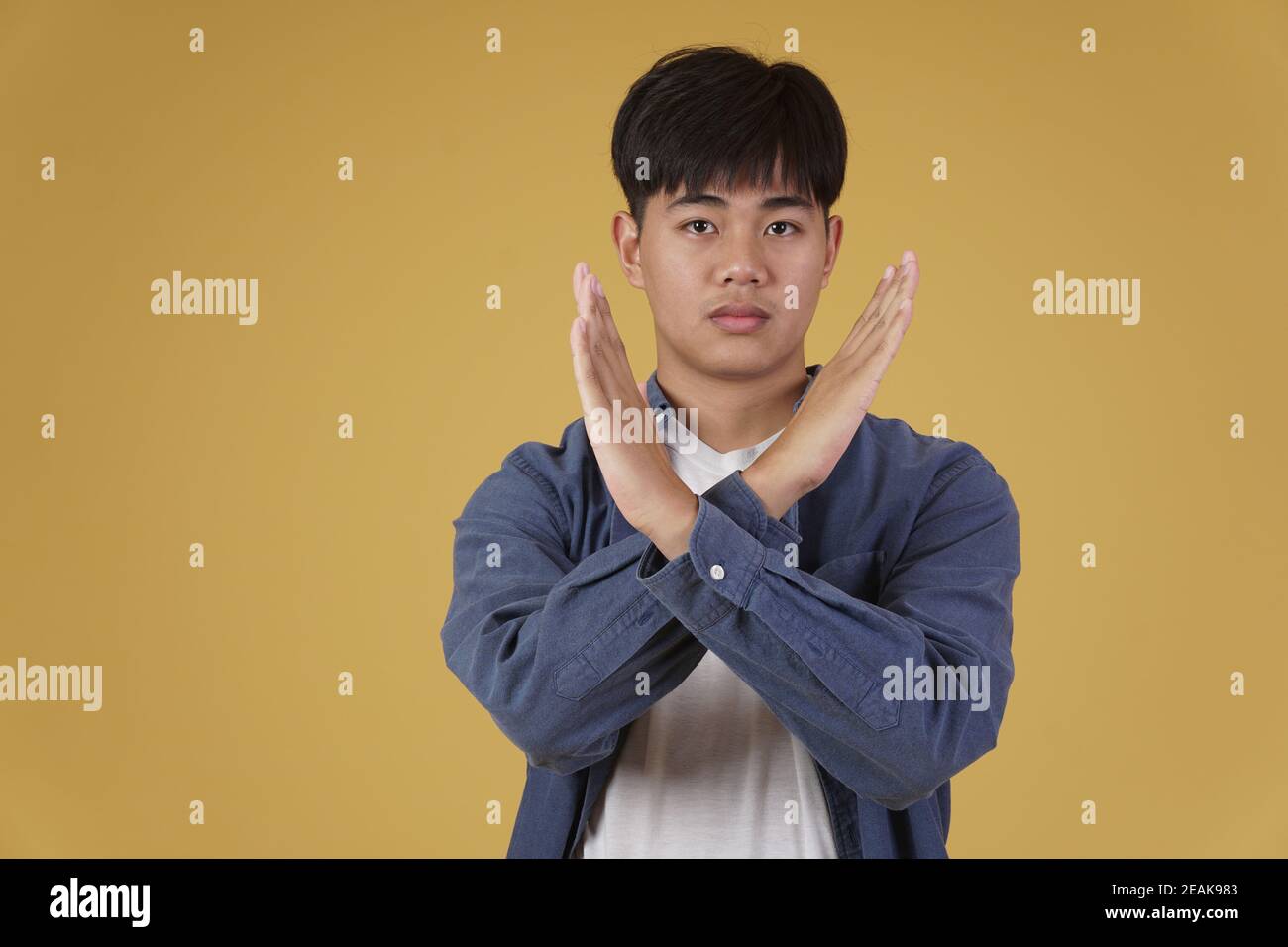 portrait of handsome young asian man dressed casually crossing arms in ...